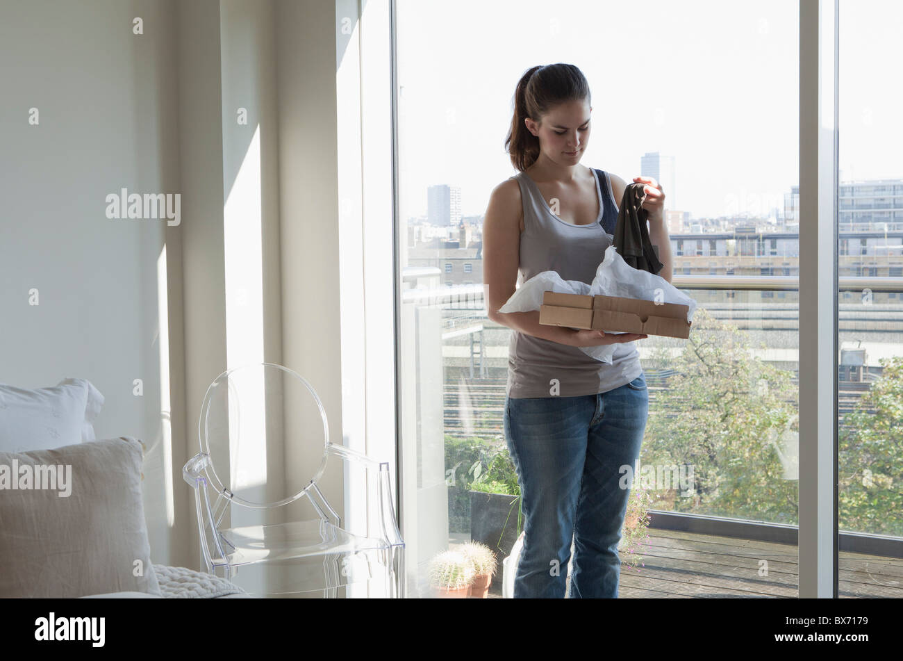 Woman opening parcel Stock Photo - Alamy