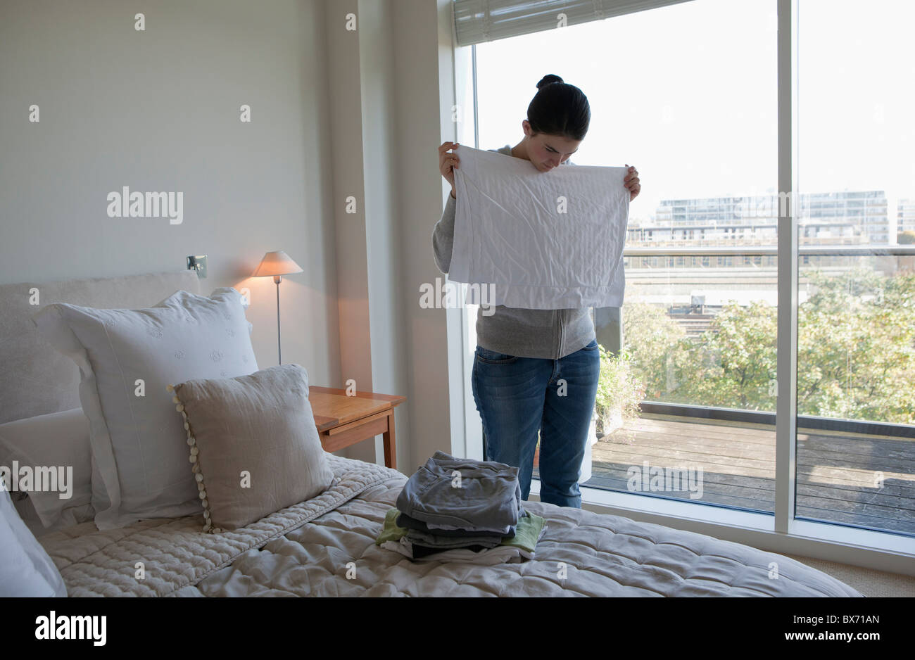 Woman folding laundry Stock Photo - Alamy