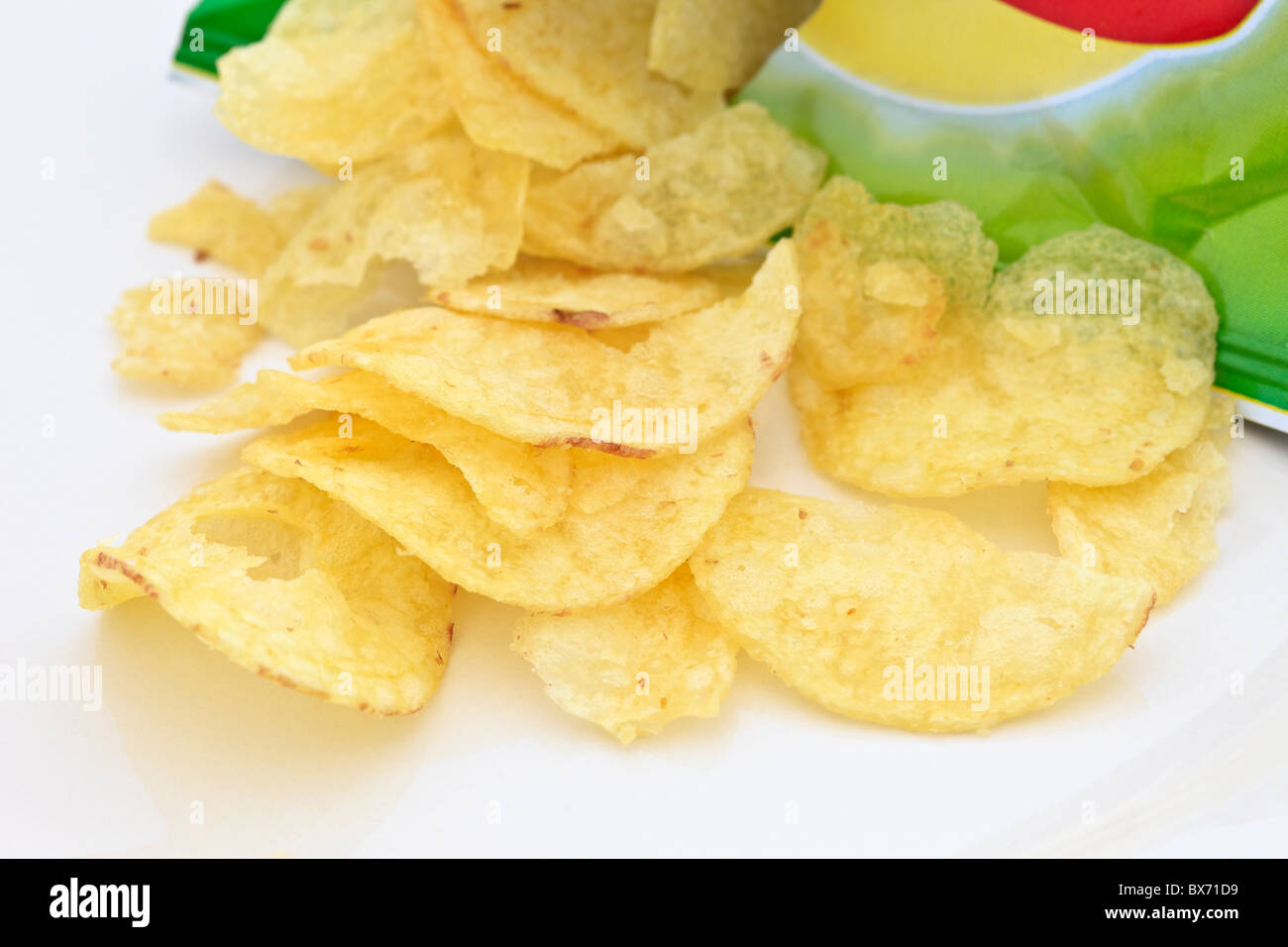 Crisp packet open with crisps spilling out Stock Photo - Alamy