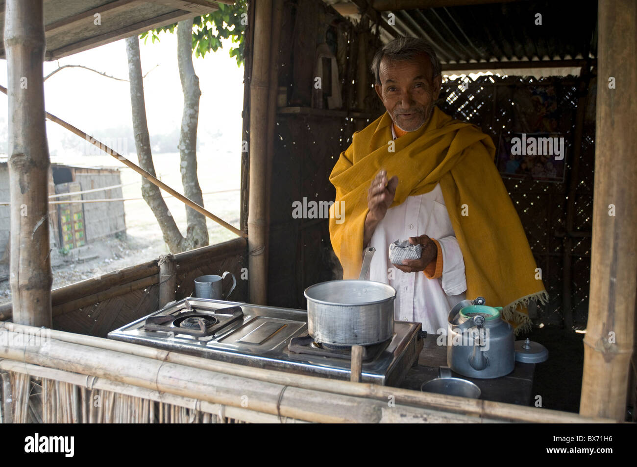 Village chai wallah (teamaker) makes the first brew of the day, Kurua ...
