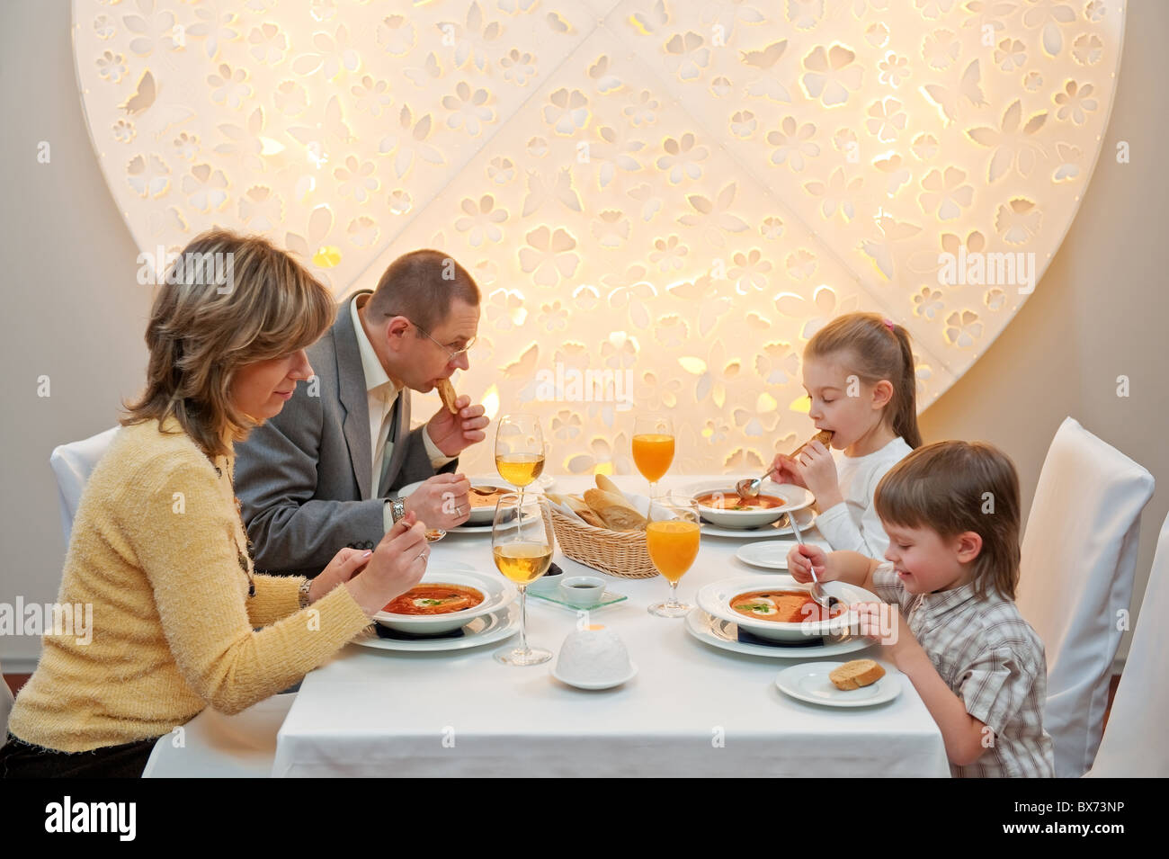 Happy family enjoying meal sitting at restaurant table Stock Photo - Alamy