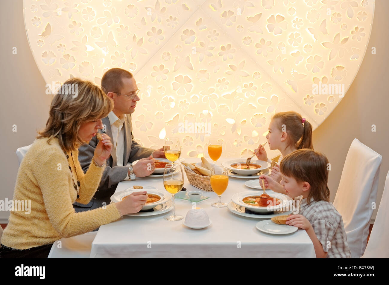 Happy family enjoying meal sitting at restaurant table Stock Photo - Alamy