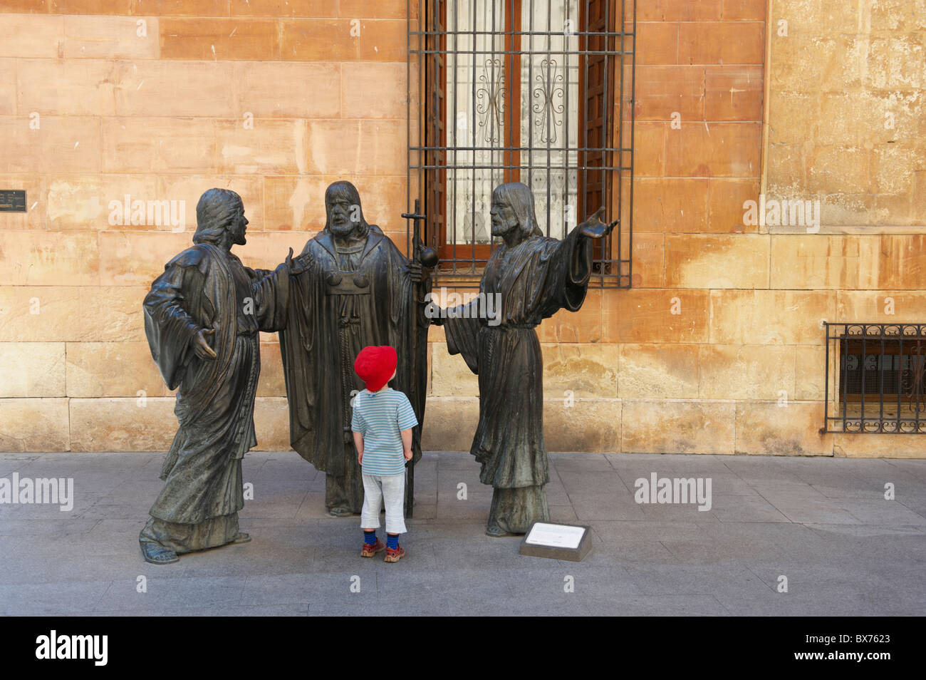 Young boy looking at religious statues in historic square Stock Photo ...