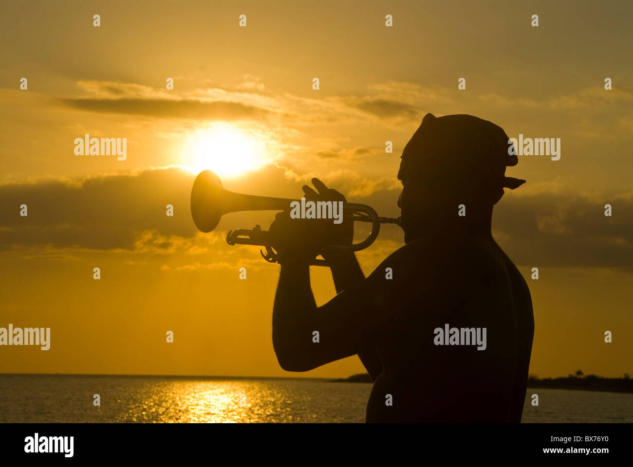 Trumpet player at sunset, Playa Ancon, Trinidad, Cuba, West Indies ...