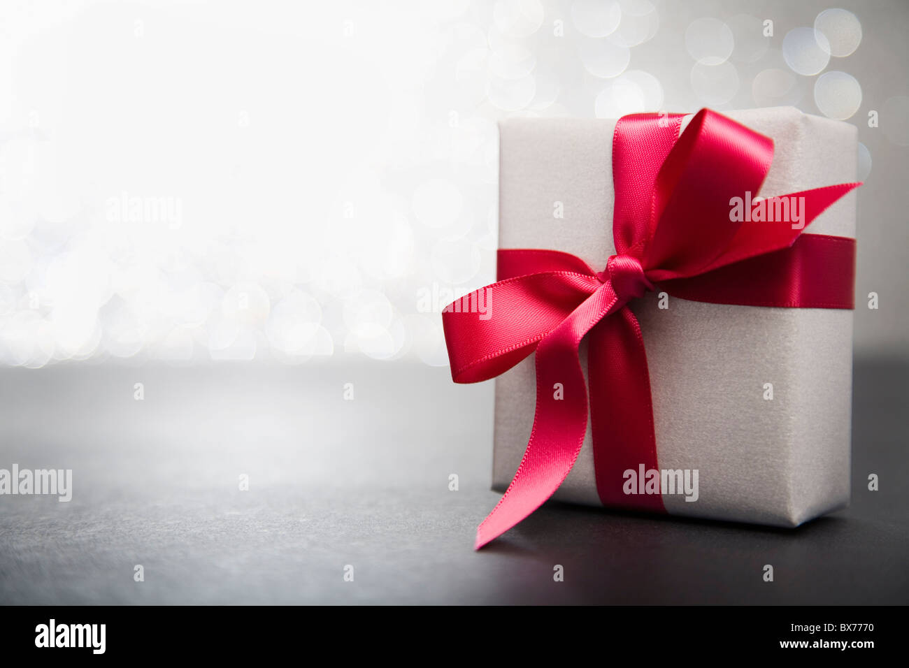 Wrapped gift with red ribbon Stock Photo - Alamy