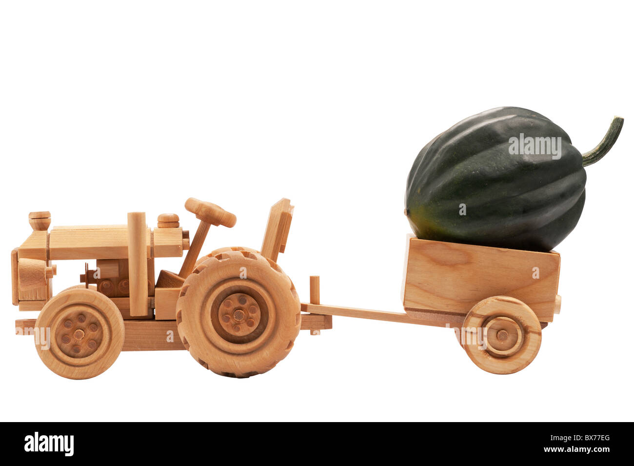 Green pumpkin in wooden toy tractor cart, isolated on white background ...