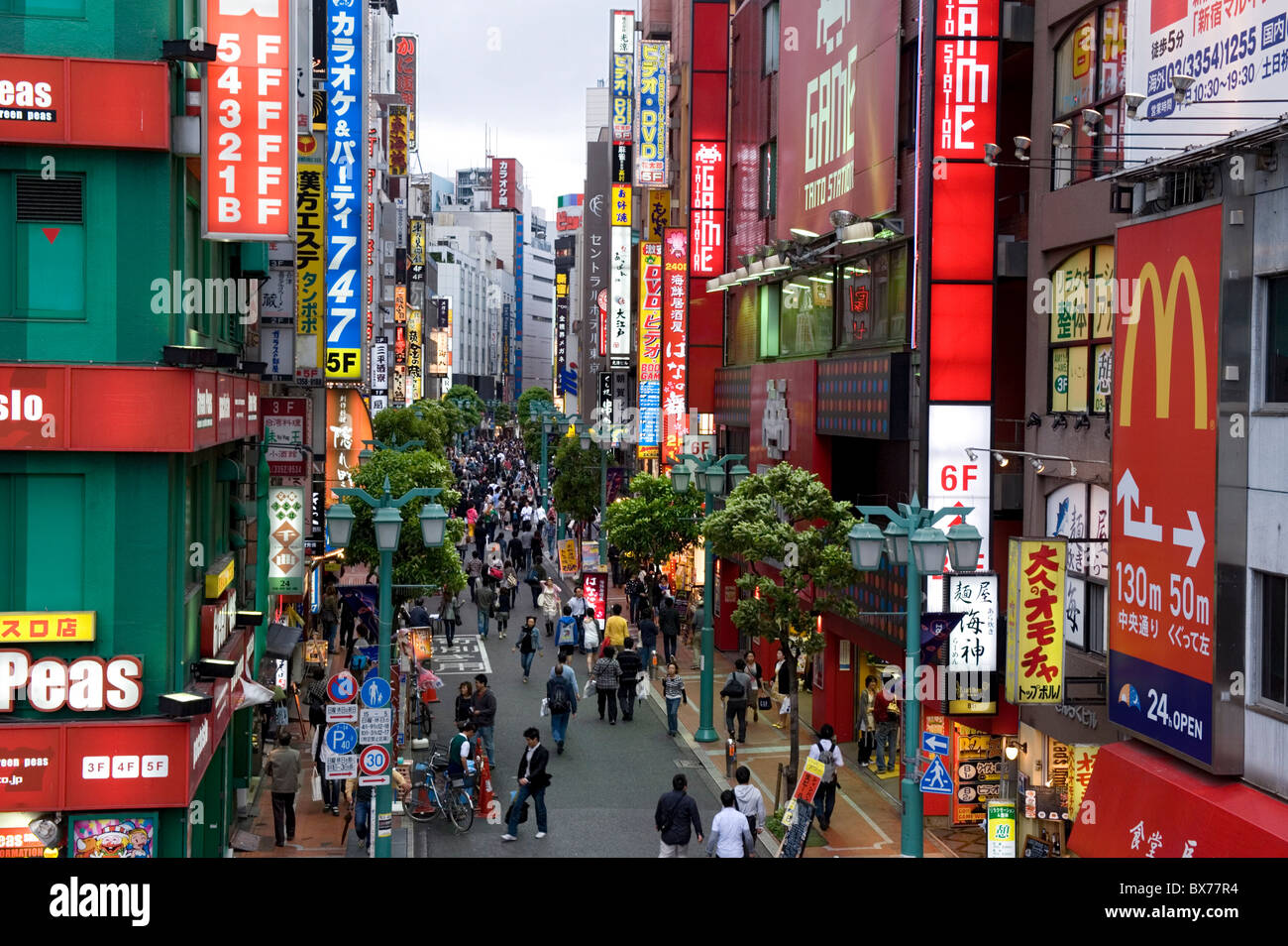 A pedestrian street lined with shops and signboards attracts a crowd in ...