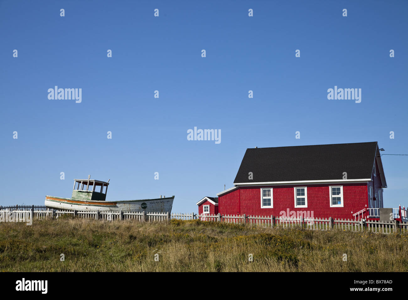 Maritime house painted red with boat on lawn, Iles de la Madeleine ...