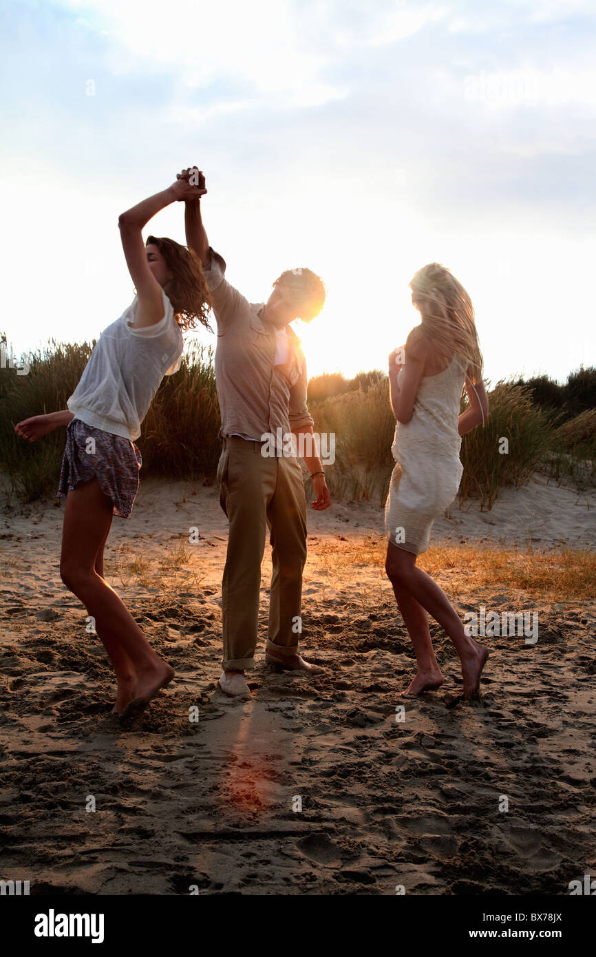 Friends dancing at the beach at sunset Stock Photo - Alamy