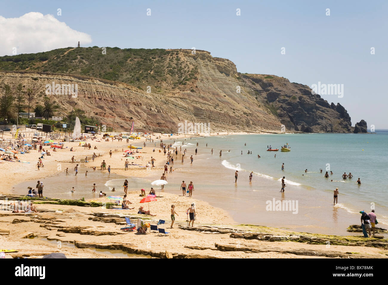 People enjoy sunshine and golden sand at the Praia da Luz beach in ...