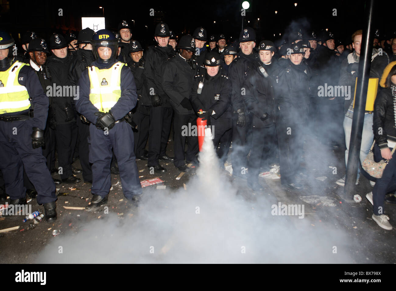Police officer with fire extinguisher at student demo Stock Photo - Alamy