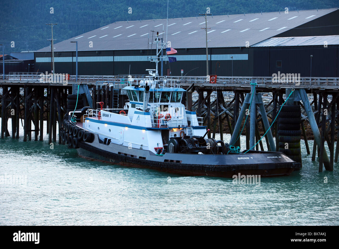 A tugboat, ship, tug boat moored to pier in sea harbor, port at Skagway ...