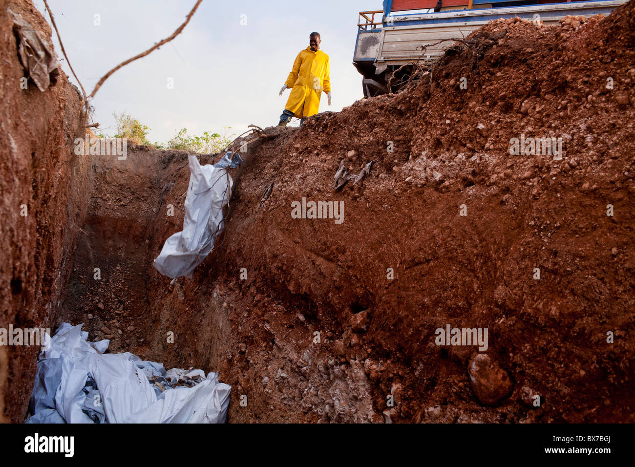 Men put the bodies of cholera victims into a mass grave on Wednesday ...