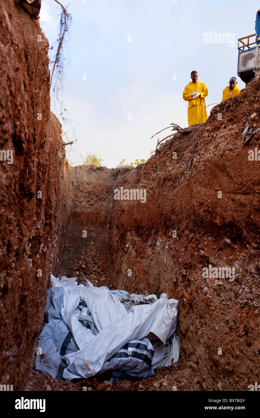 Men put the bodies of cholera victims into a mass grave on Wednesday ...