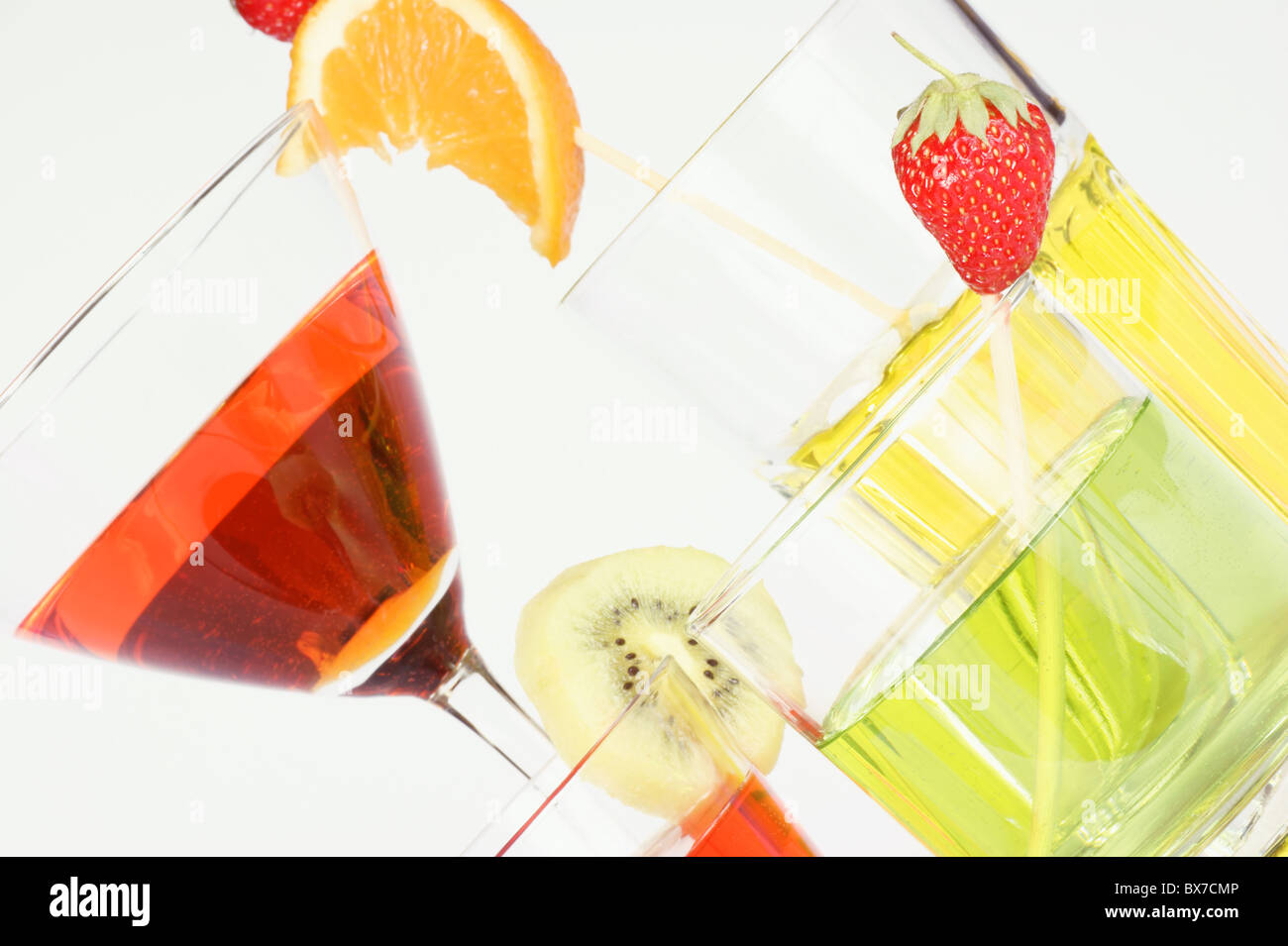 Colored aperitif drinks decorated with fresh fruit served in different ...