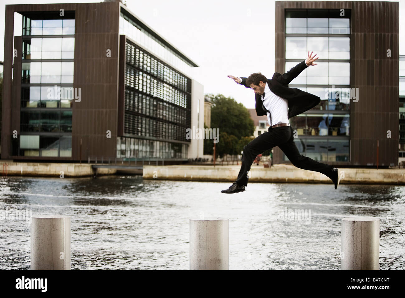 Man jumping from pole to pole Stock Photo - Alamy