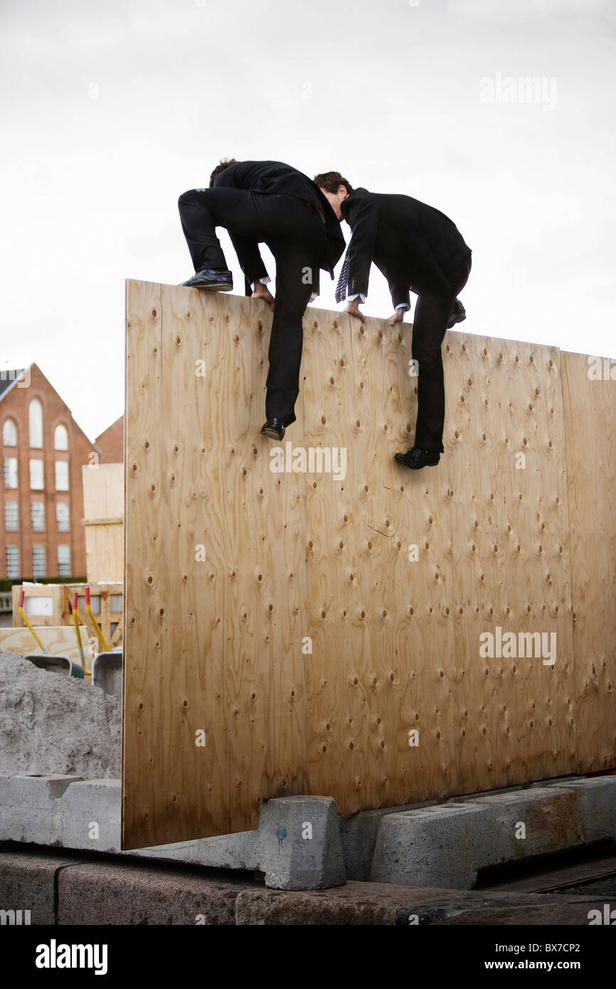 To men climbing wall Stock Photo - Alamy