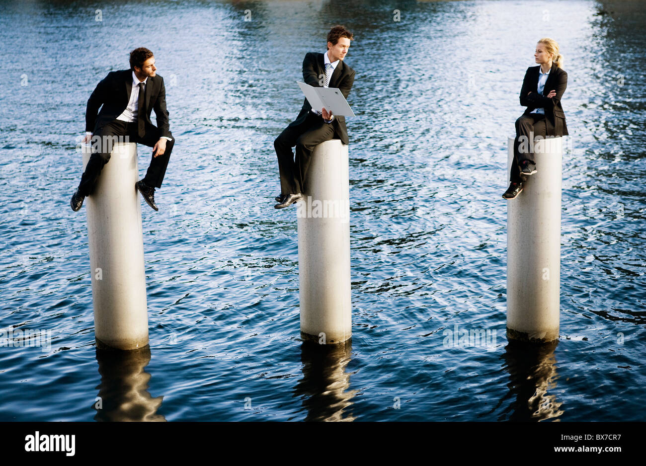 3 people on poles Stock Photo - Alamy