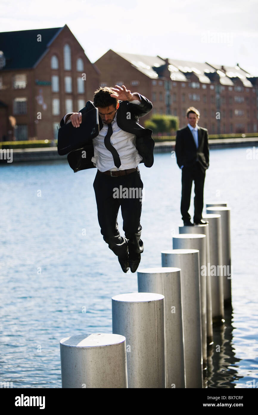 Man jumping from pole to pole Stock Photo - Alamy