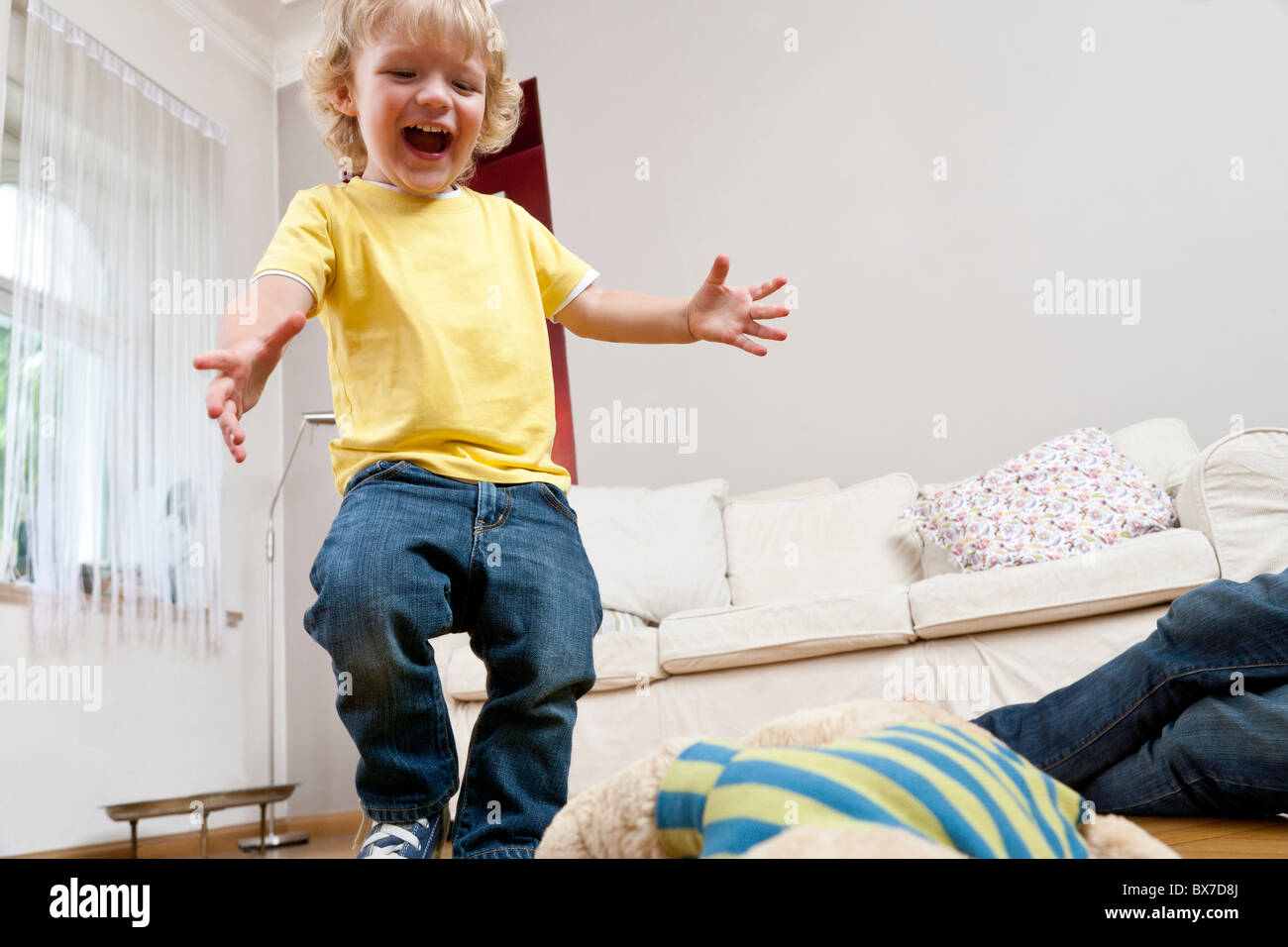Boy jumping in living room Stock Photo - Alamy