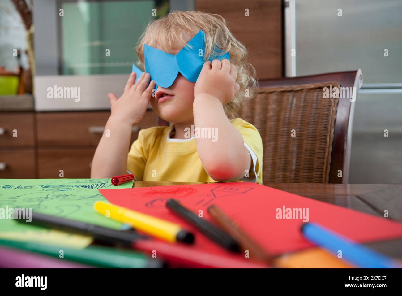 Boy hiding behind paper Stock Photo - Alamy