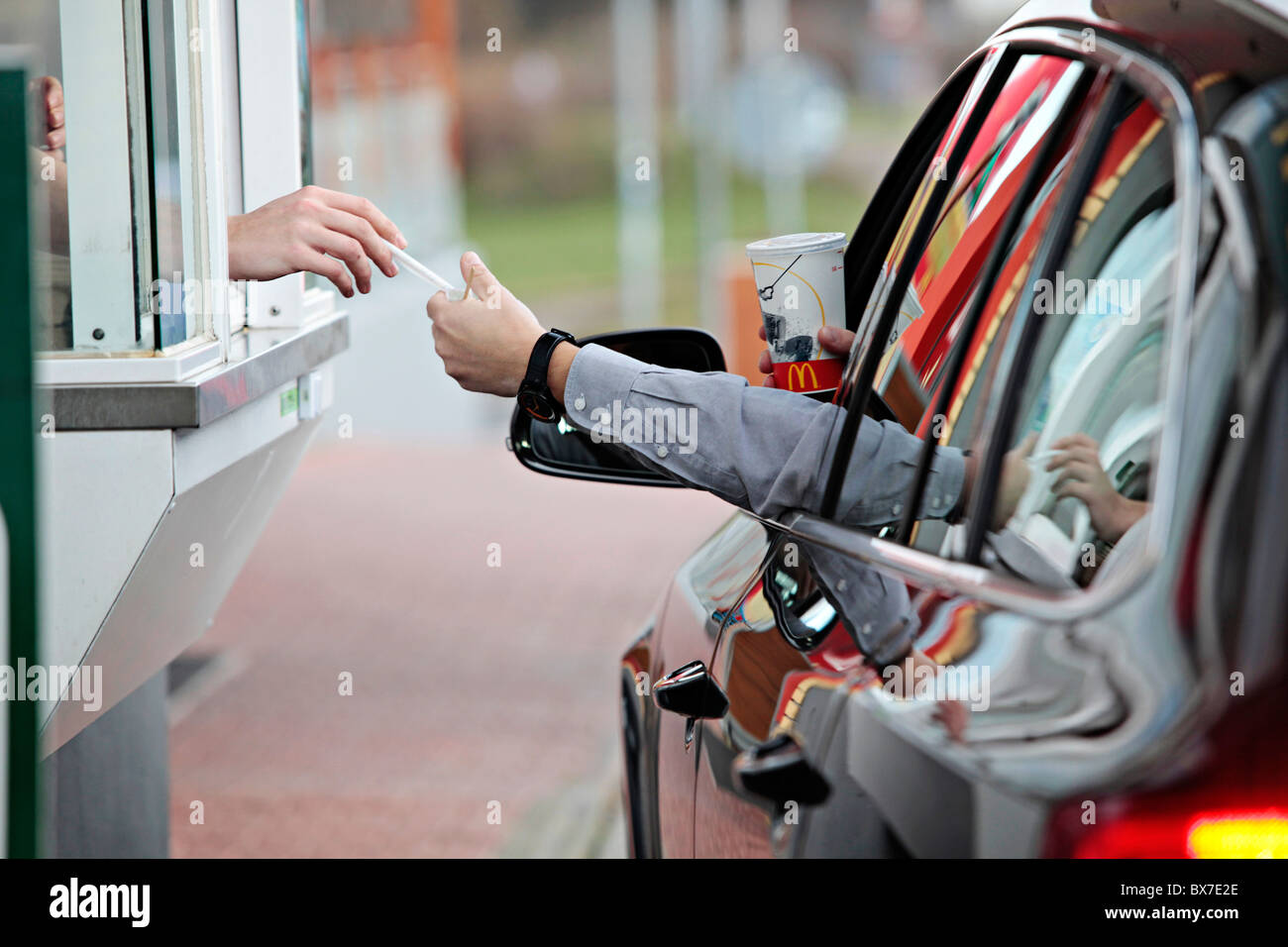 A driver, man, drink, coke, paper cup, drive thru, driving, eating ...