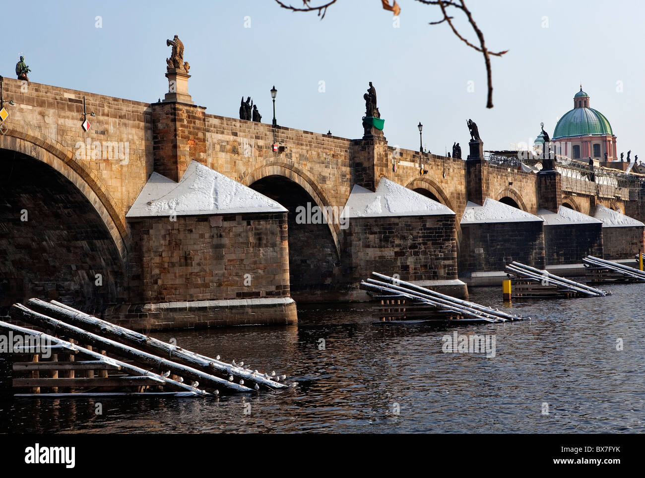 Prague - snow covered Baroque statues and pillars of Charles Bridge ...