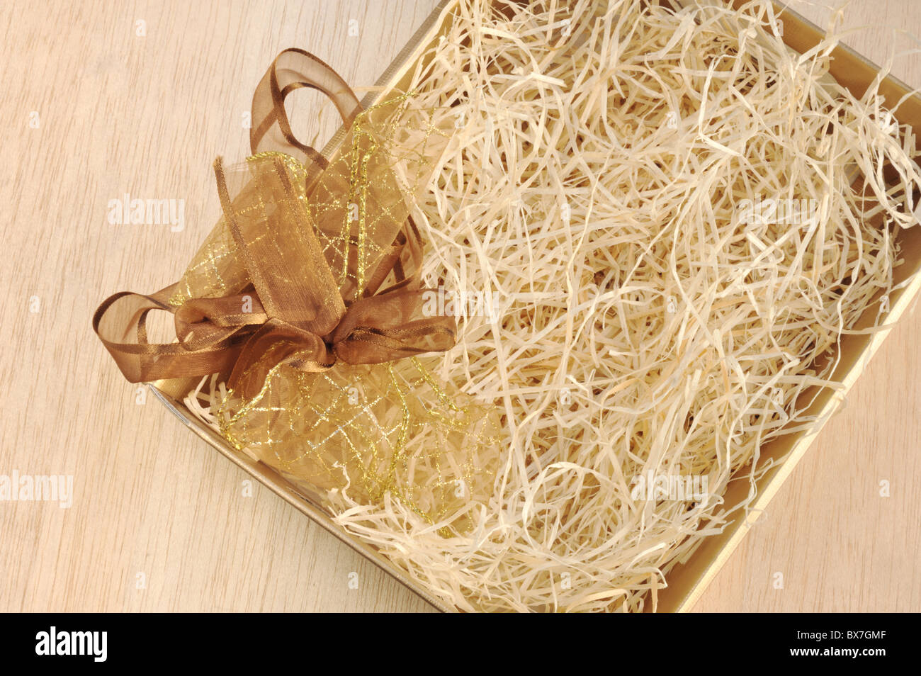 Open gift box and bow - filled with packing bast - detail Stock Photo ...