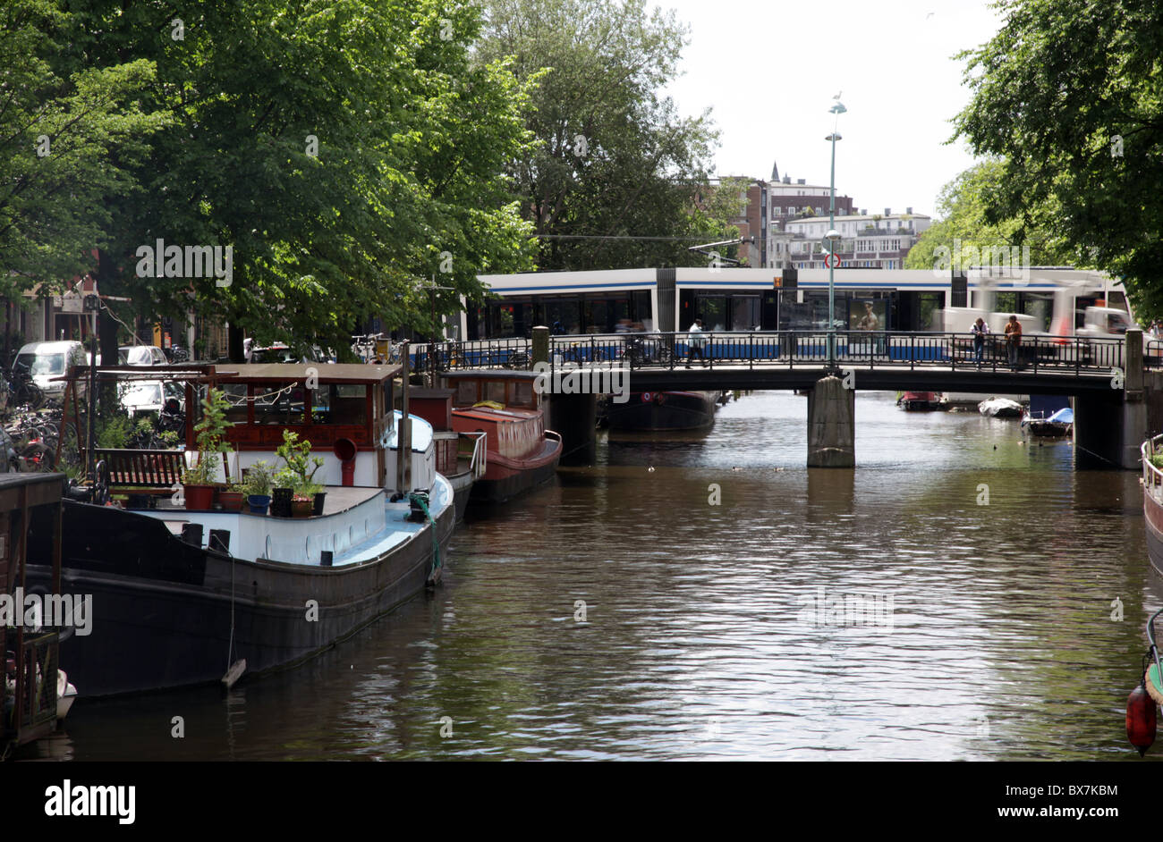 tram crossing bridge over canal with house boats in front Stock Photo ...
