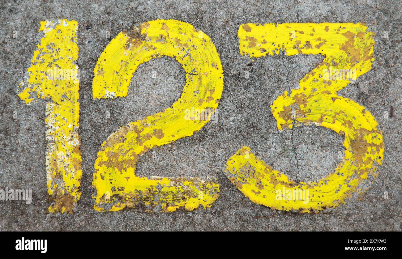 123 painted in yellow on grey concrete ground Stock Photo - Alamy
