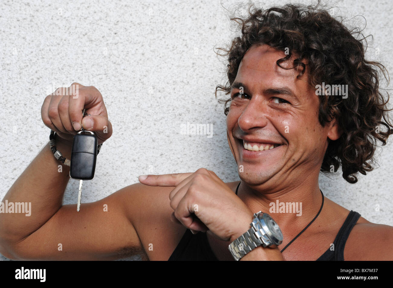 Young man holding a car key and proudly smiling Stock Photo - Alamy