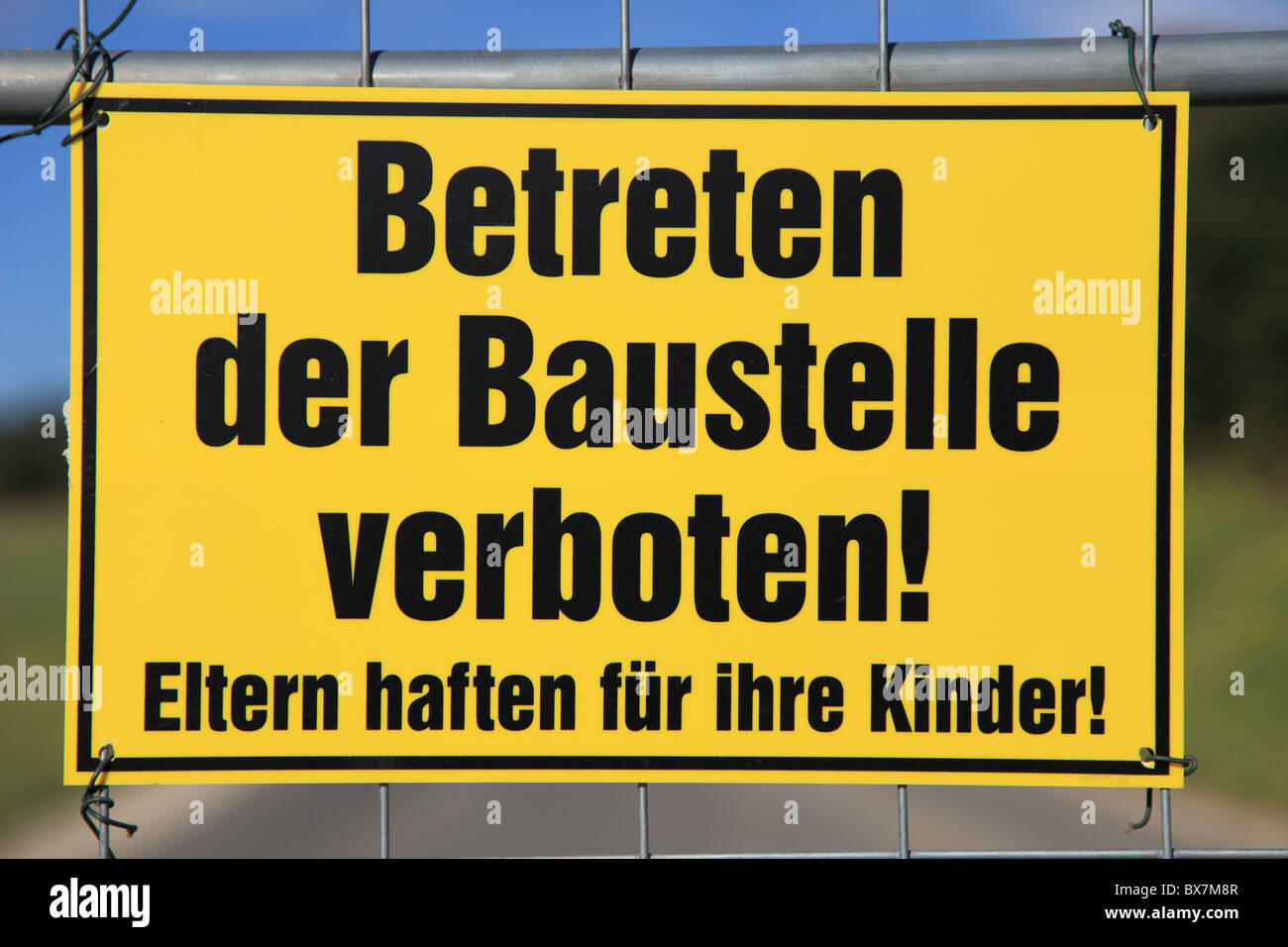 Yellow warning sign in front of construction sign in german lnaguage ...