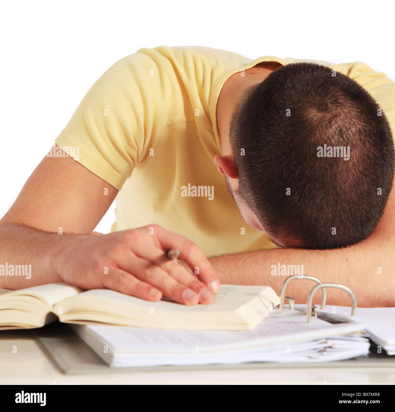 Male student taking a nap on his study papers. All on white background ...