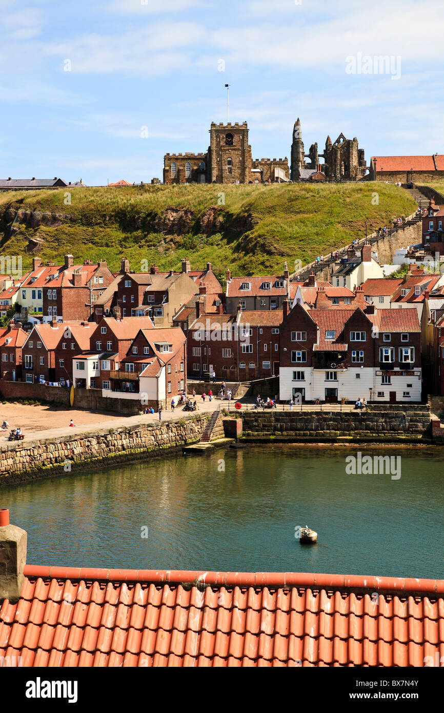 Whitby Harbor on a sunny day with the Abbey on the hill top over ...