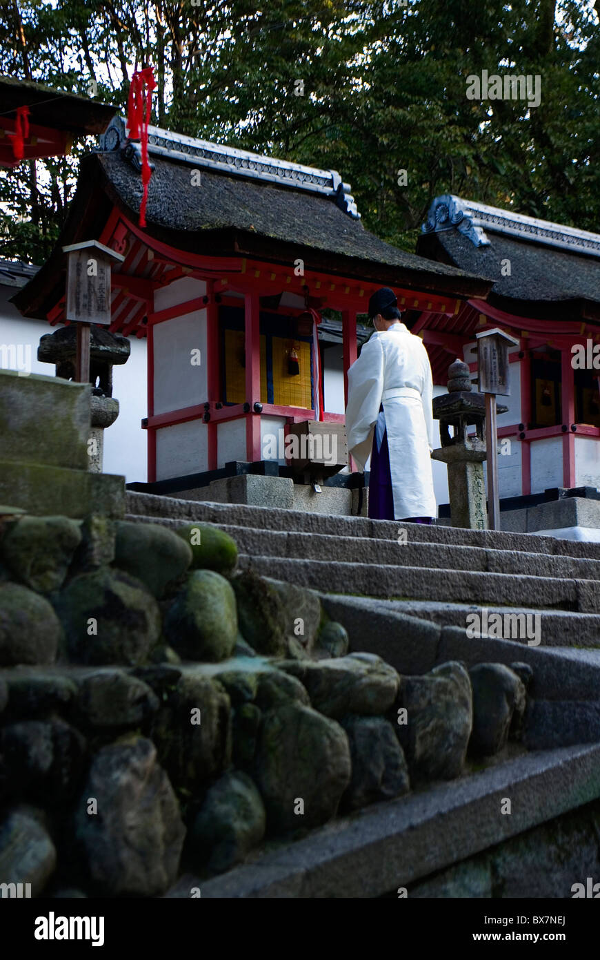 Shinto monk doing morning prayers at Fushimi Inari shrine, Kyoto, Japan ...