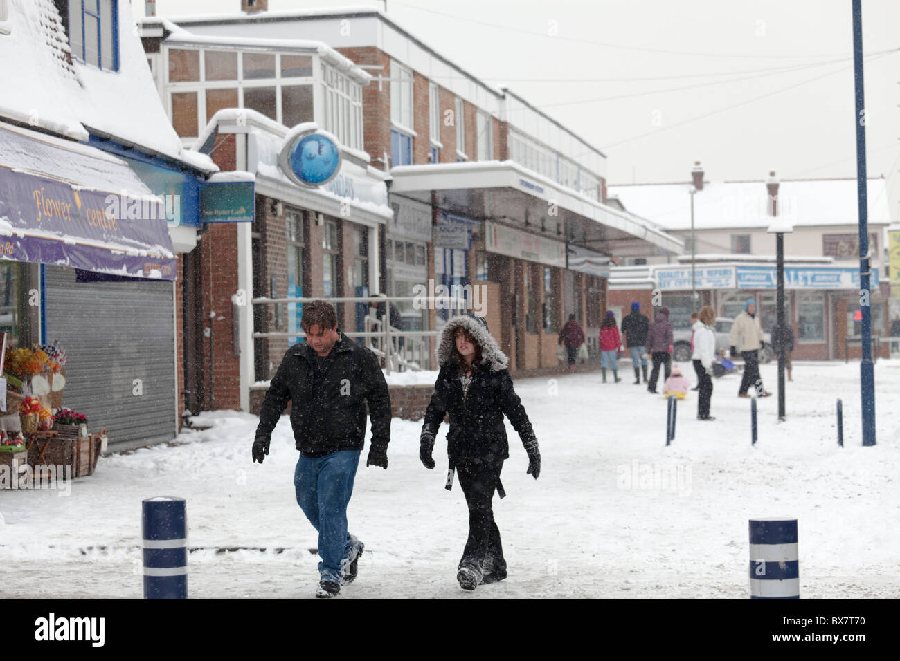 shoppers using local shops in snow covered village Stock Photo - Alamy