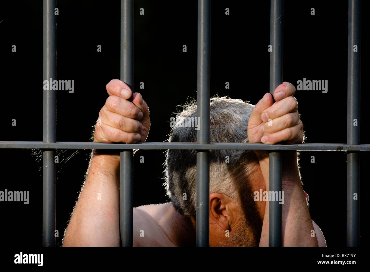 Offender behind bars Stock Photo - Alamy