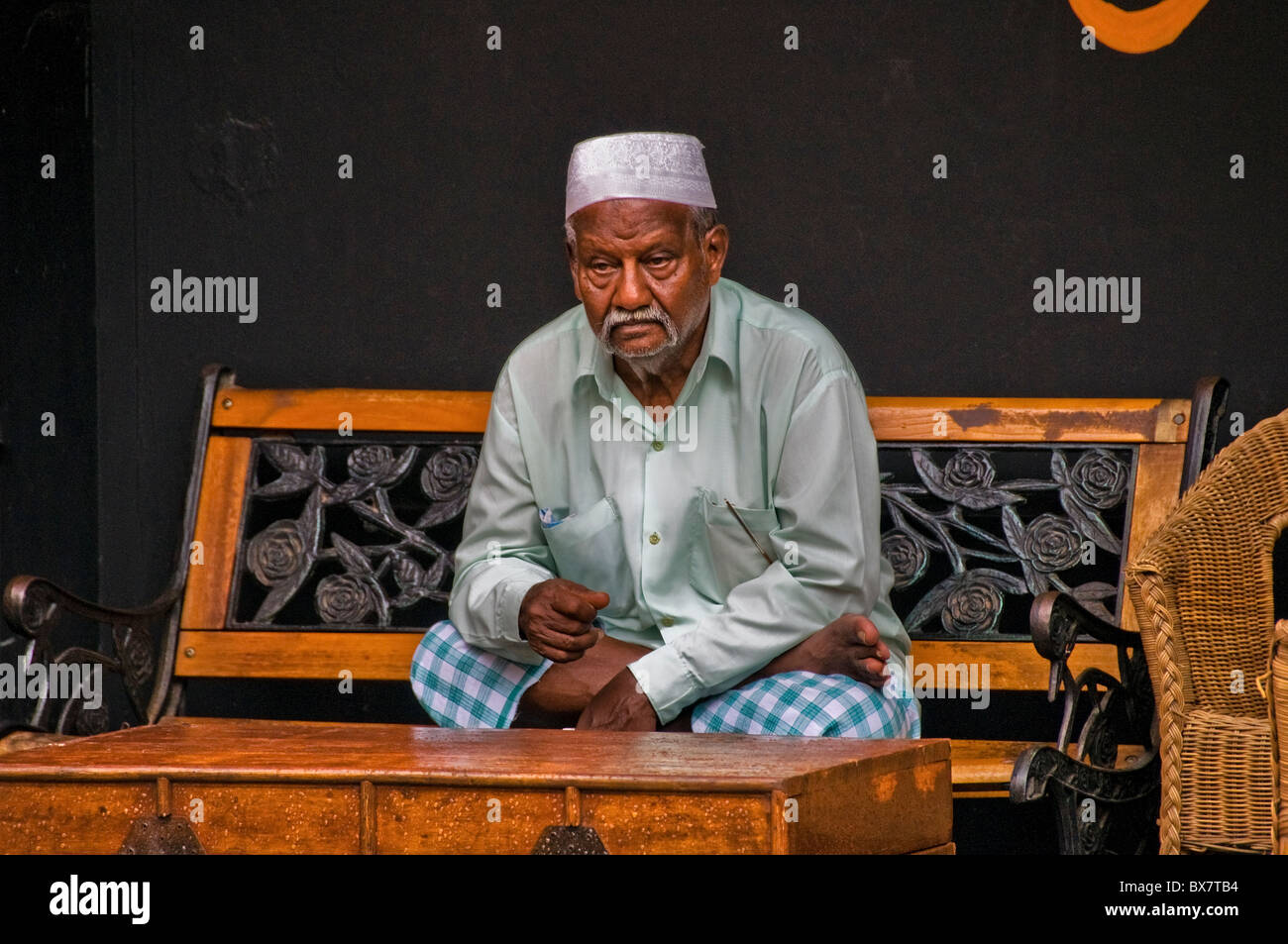 Distinguished older Muslim man sitting on bench in Arab quarter ...