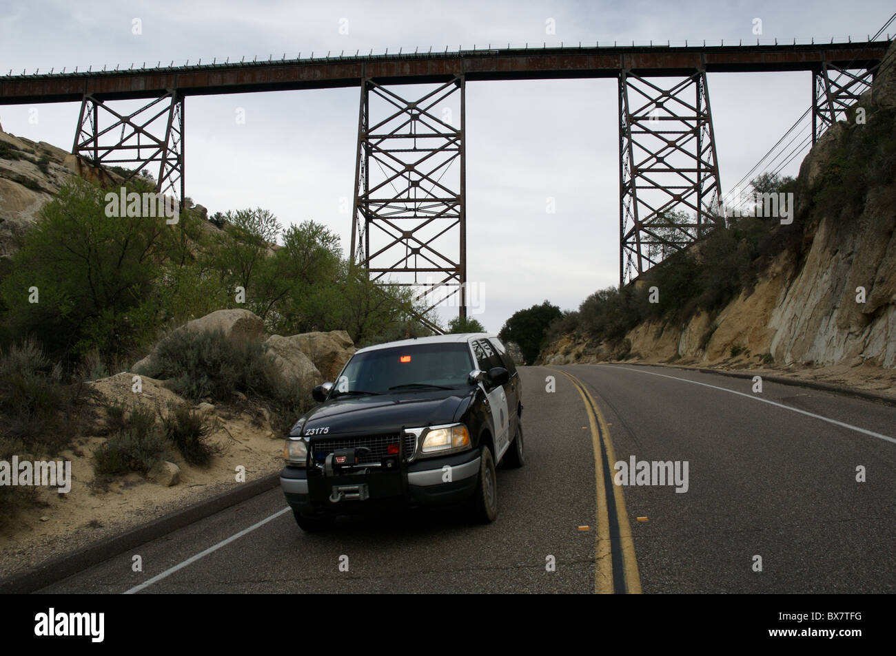A police vehicle passes under a railroad bridge on Highway 94, just ...
