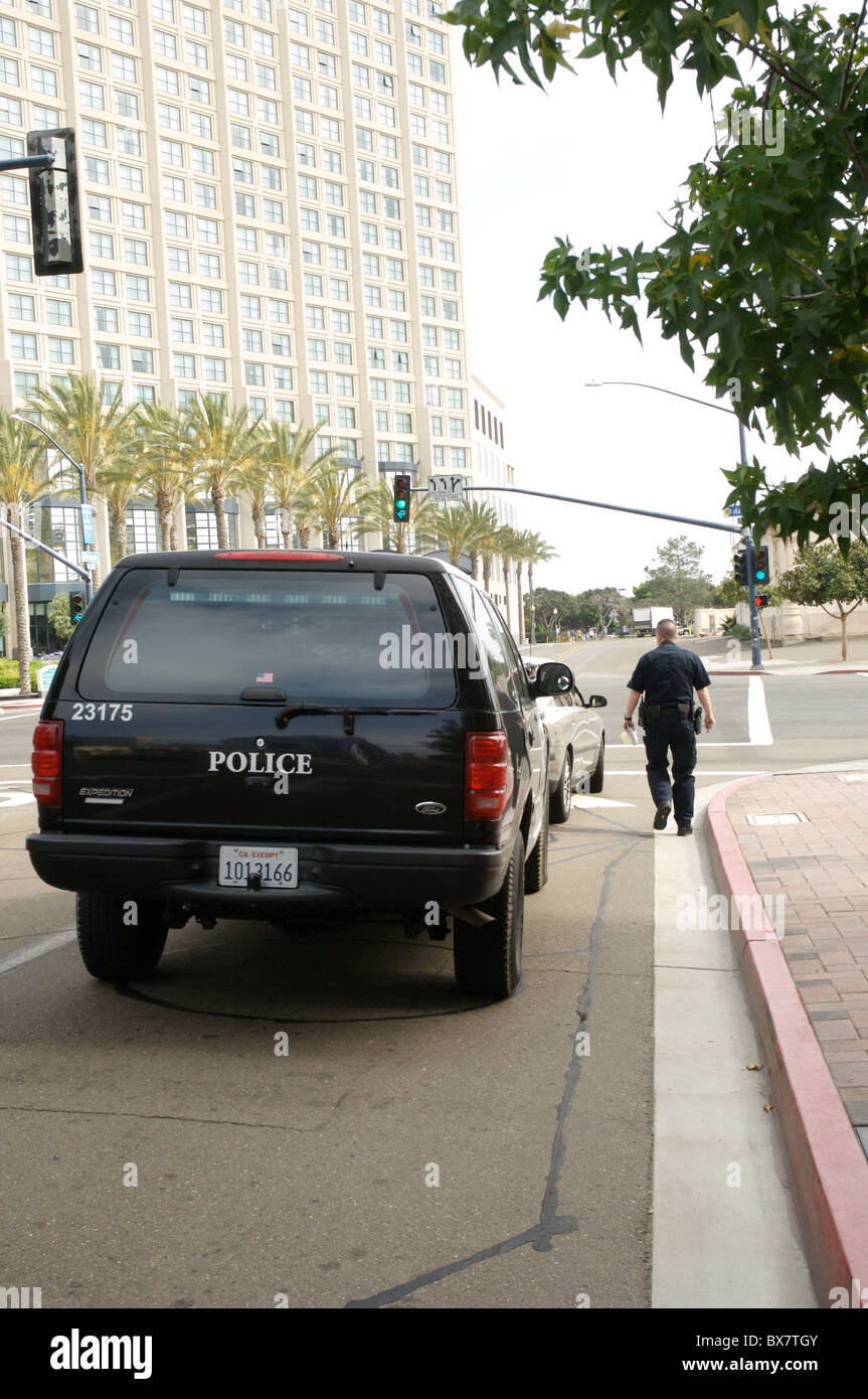 A police officer approaches the passenger side of a vehicle during a ...