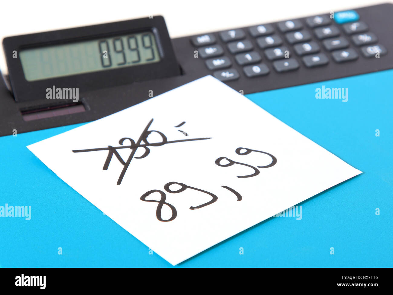 Piece of paper showing the amount of 89,99 lying on a calculator ...