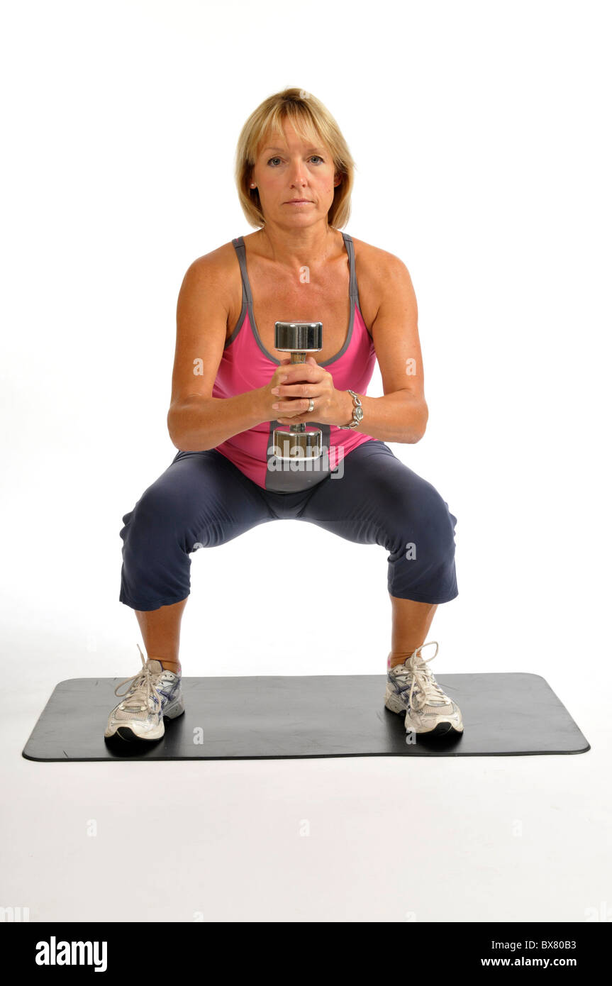 50 yr old female demonstrates box step up with dumb bell Stock Photo ...