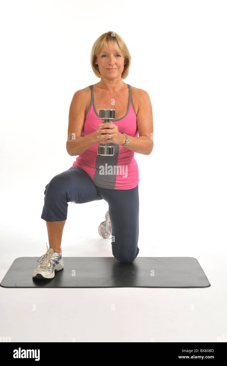 50 yr old female demonstrates box step up with dumb bell Stock Photo ...