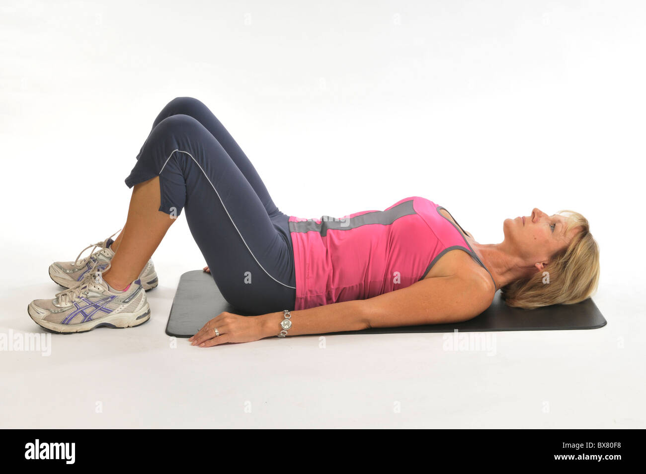 50 yr old doing bridge stretch on mat in studio Stock Photo - Alamy