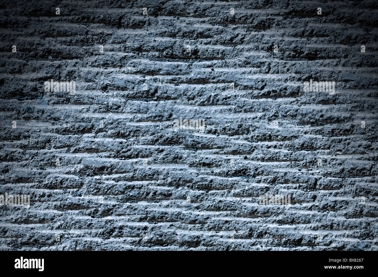 Grooved asphalt or rock surface texture lit from above with blue light ...