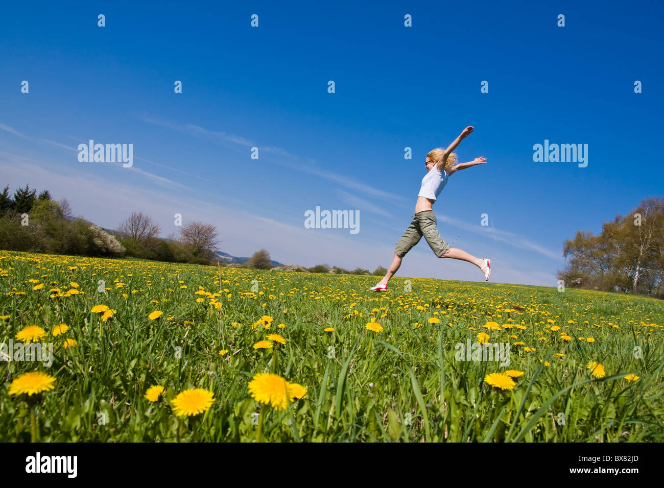 young female having fun on flowery meadow Stock Photo - Alamy