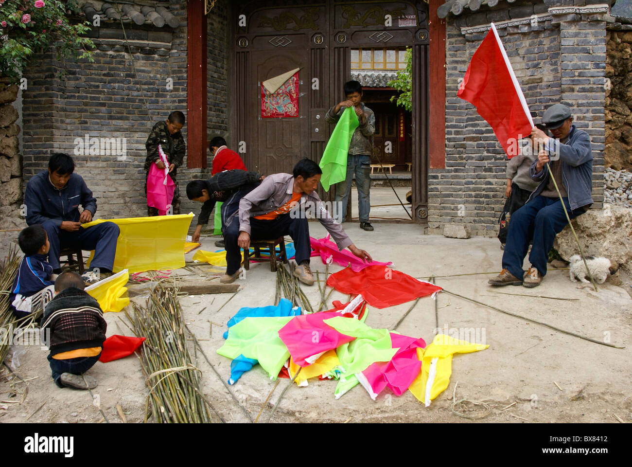 Naxi men and boys making decorative flags, Yuhu, Lijiang, Yunnan, China ...