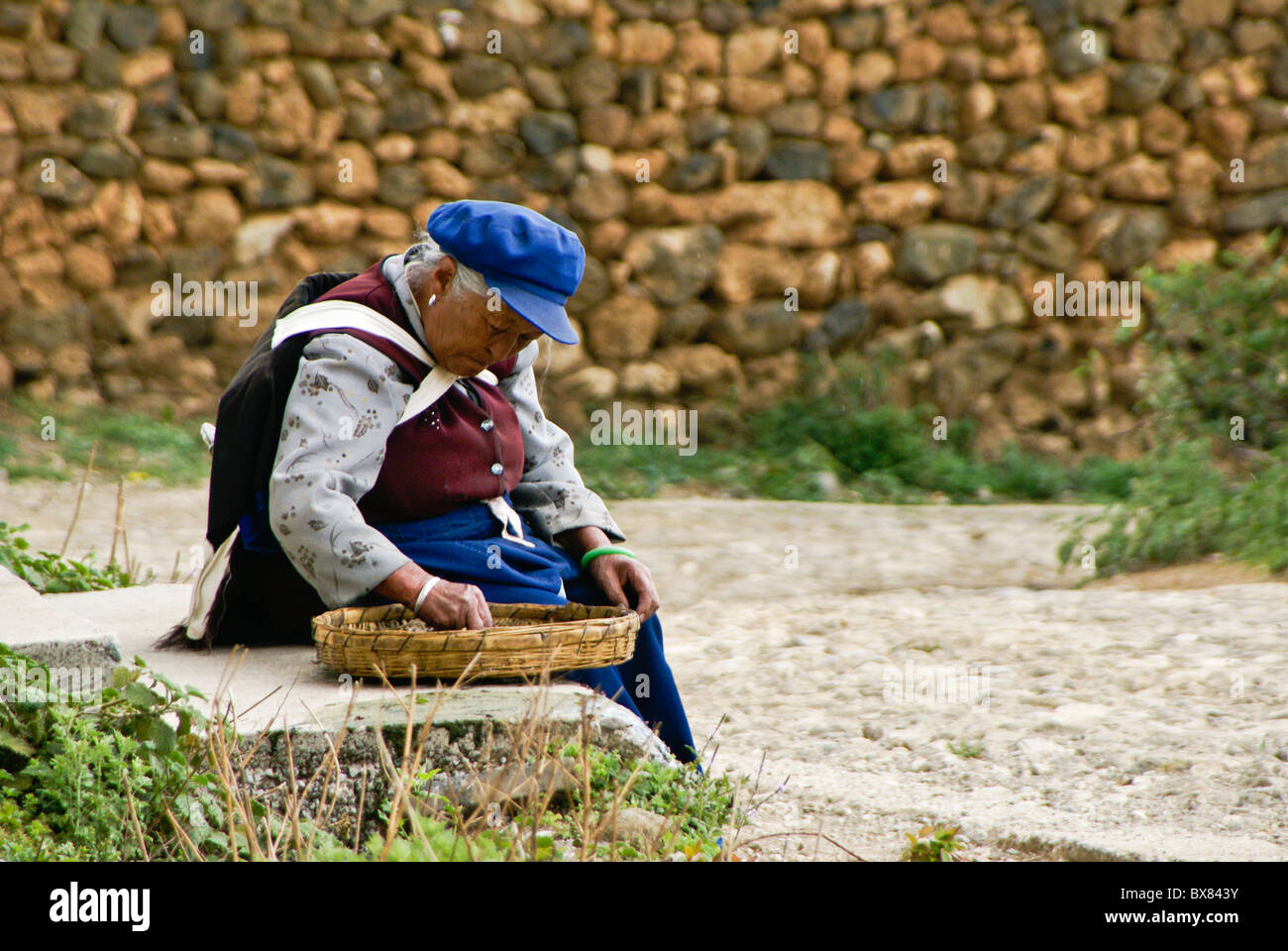 Naxi woman cleaning rice in village of Yuhu, Lijiang, Yunnan, China ...