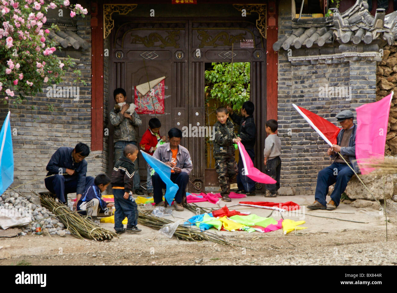 Naxi men and boys making decorative flags, Yuhu, Lijiang, Yunnan, China ...