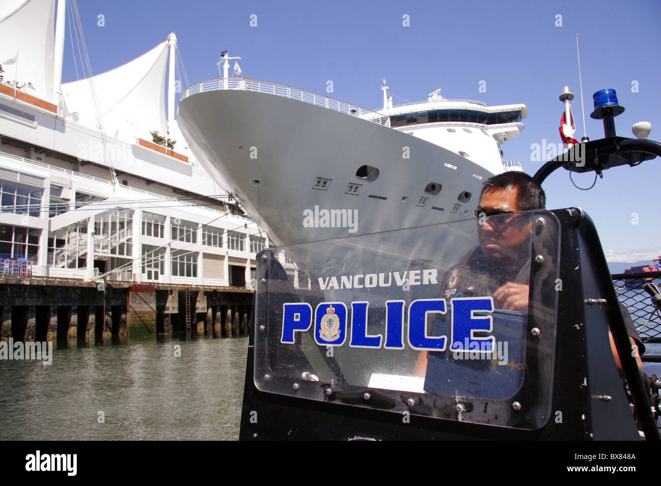 Vancouver Police Marine Unit boat patrolling near a cruise liner ship ...